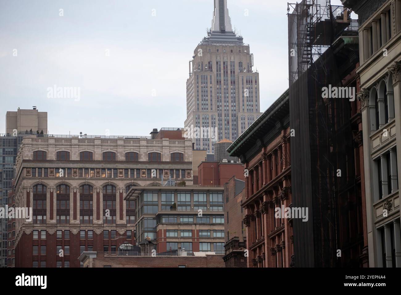 The photograph captures a view of the Empire State Building, rising prominently among ...
