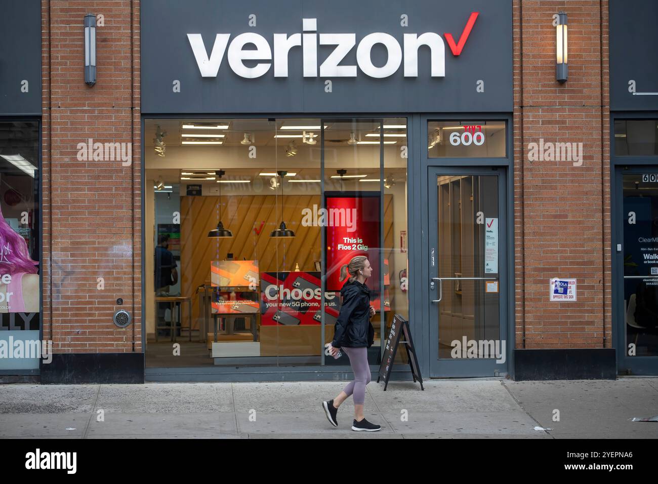 The photograph shows the exterior of a Verizon store with its ...