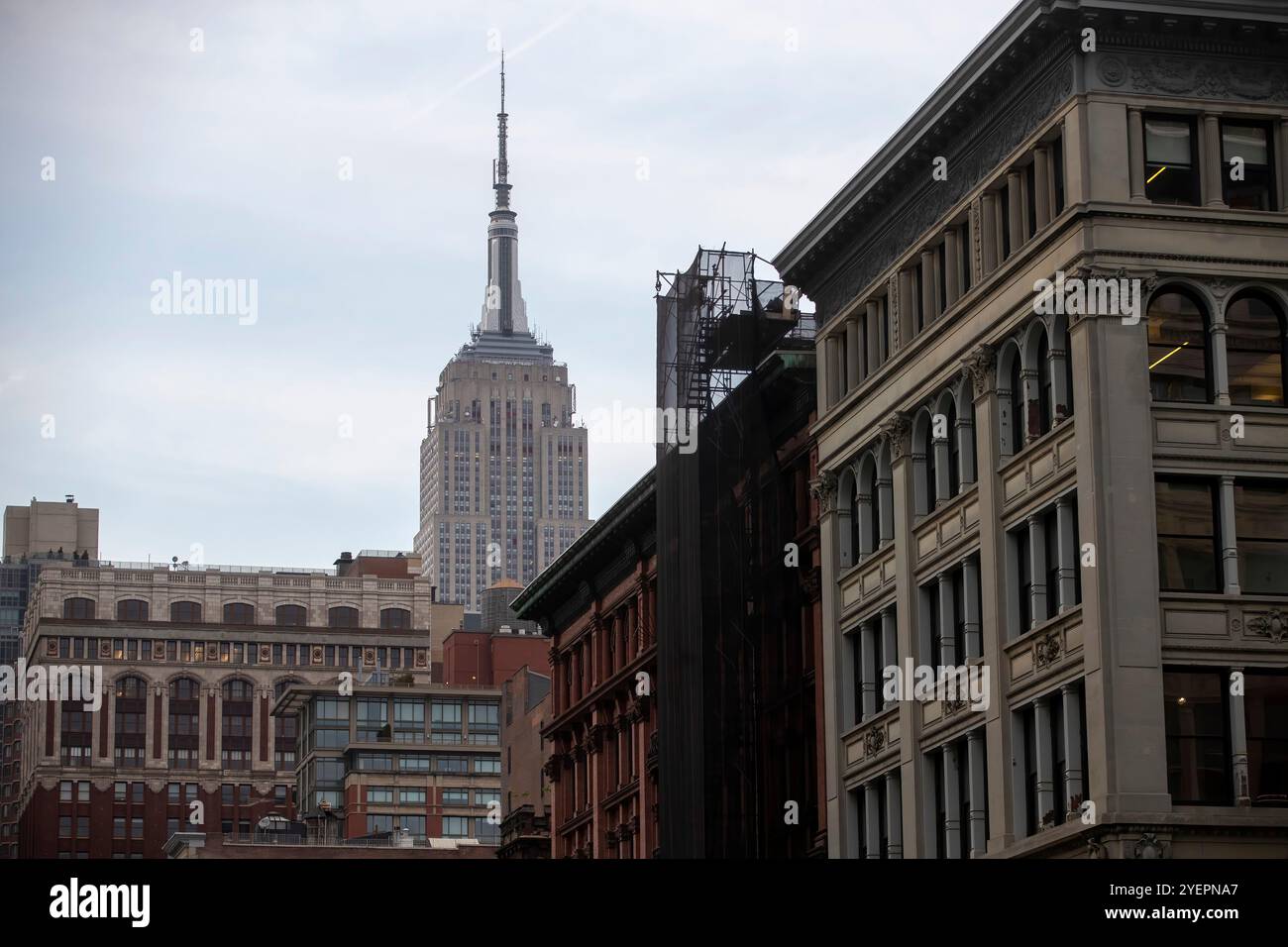 The photograph captures a view of the Empire State Building, rising prominently among ...