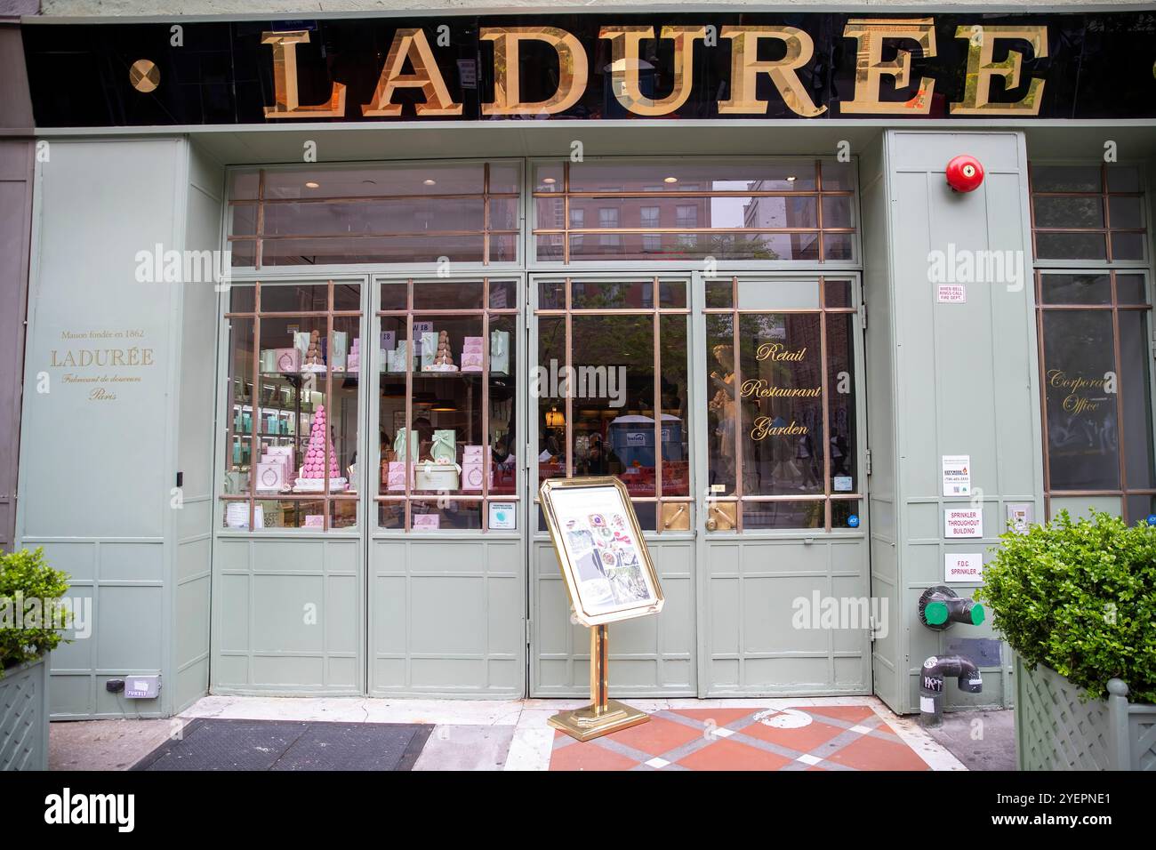 This photograph shows the exterior of a Ladurée storefront, featuring ...