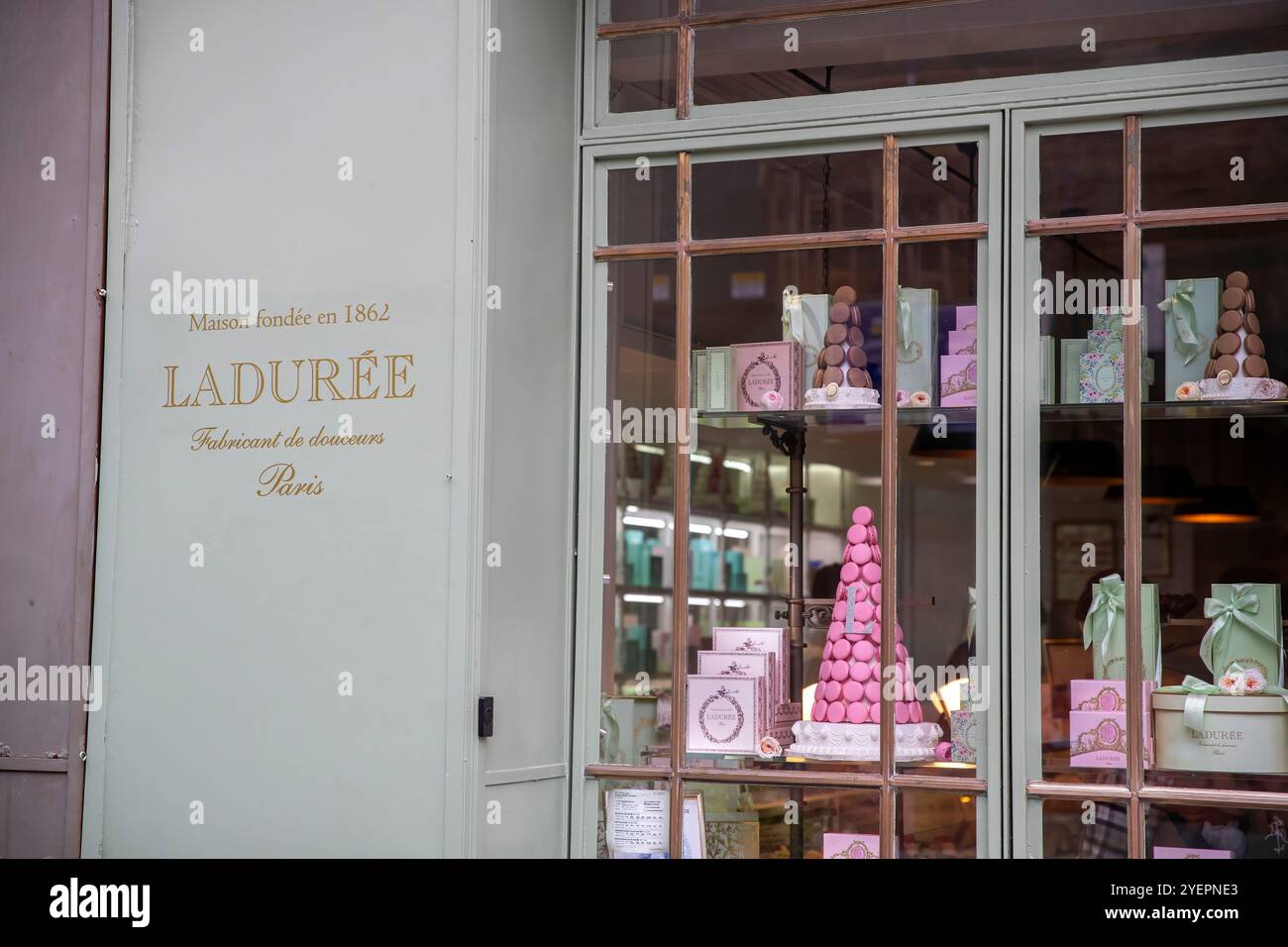 This photograph shows the exterior of a Ladurée storefront, featuring ...