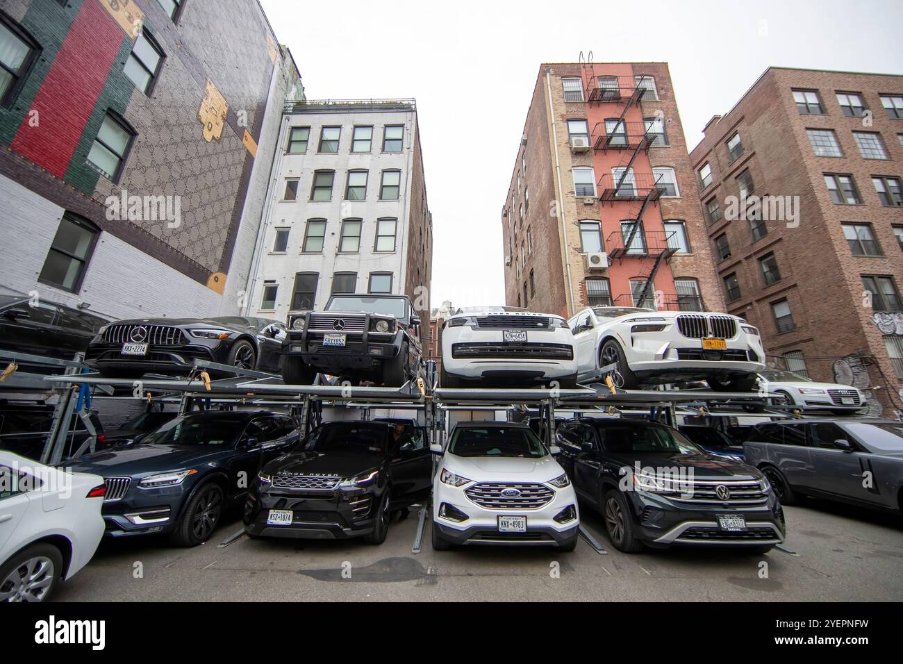 This photograph depicts a busy urban scene with a car parking lot ...