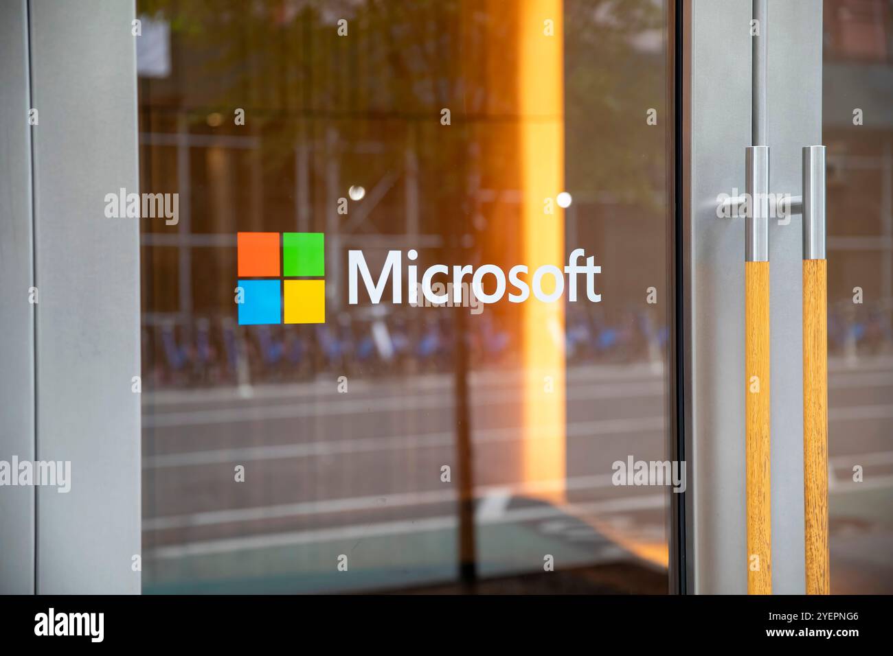 This image shows the Microsoft logo on a glass storefront, with ...