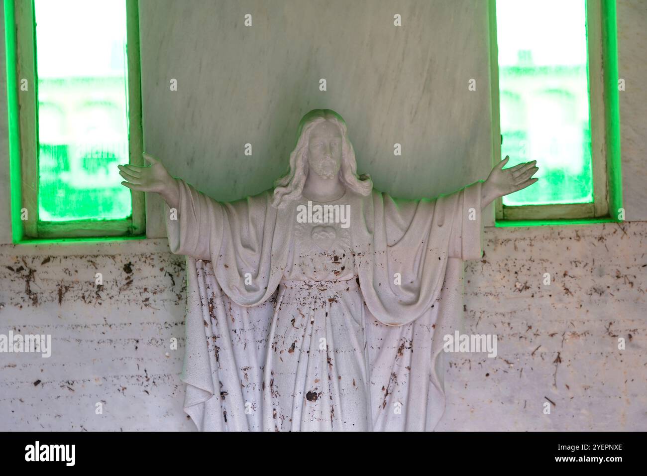 A mud splattered statue of Christ is seen inside a cemetery on the ...