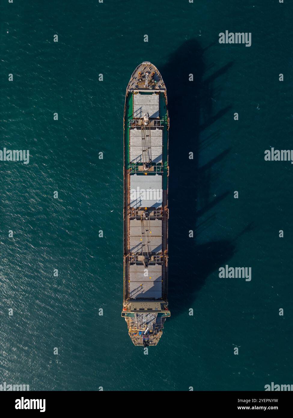 Top-down aerial drone view of a large cargo ship sailing on open water ...
