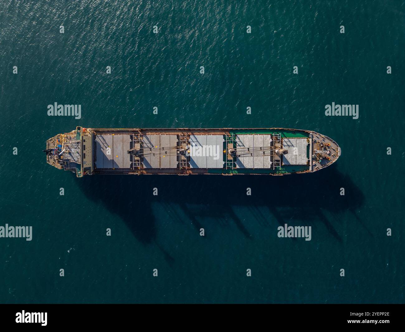 Top-down aerial drone view of a large cargo ship sailing on open water ...