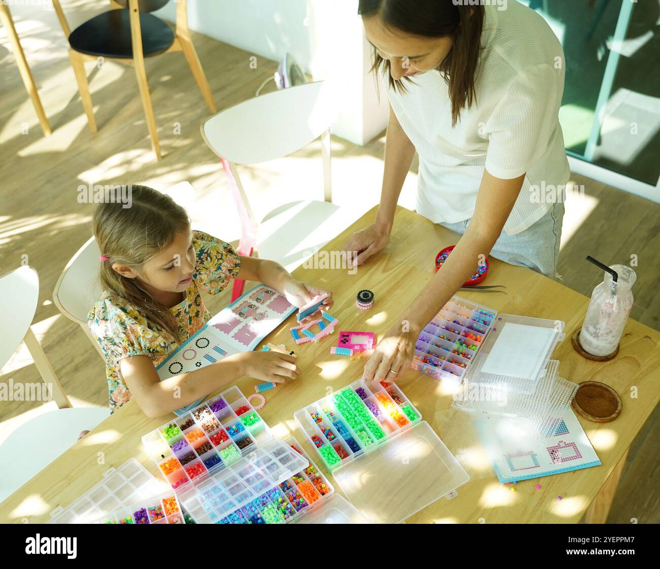 Teacher in workshop teched two girls how to assemble a thermo mosaic ...