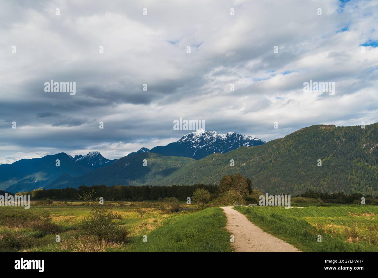 Pathway with mountain background and dramatic clouds Stock Photo - Alamy