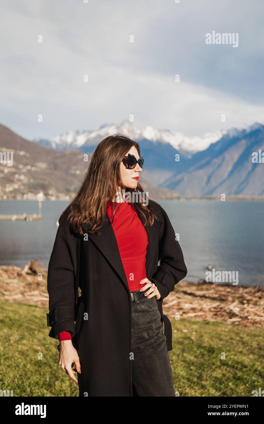 Beautiful young woman in black coat, red blouse and sunglasses Stock ...