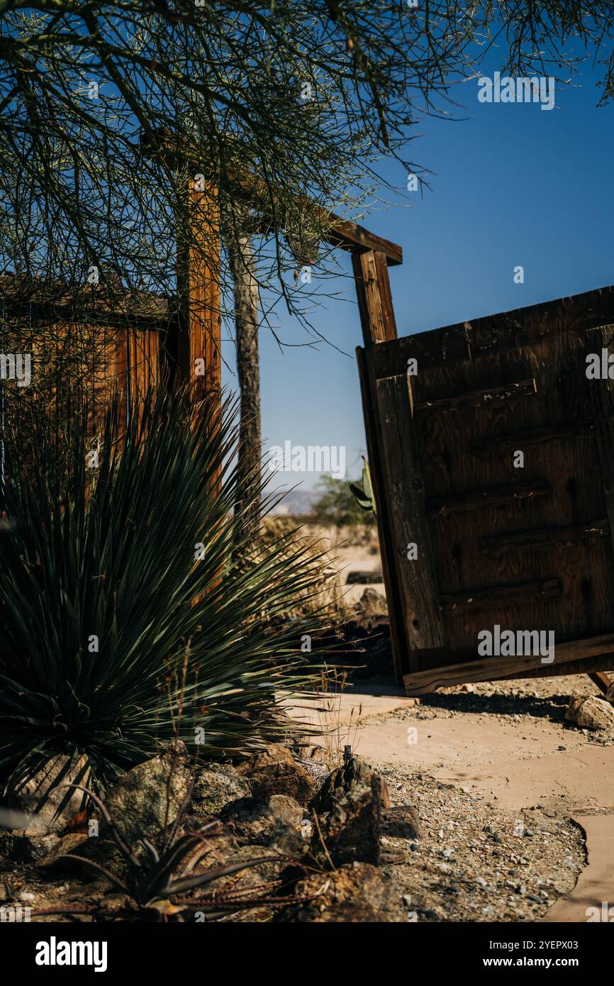 Rustic desert gate with agave and dry vegetation in foreground Stock ...