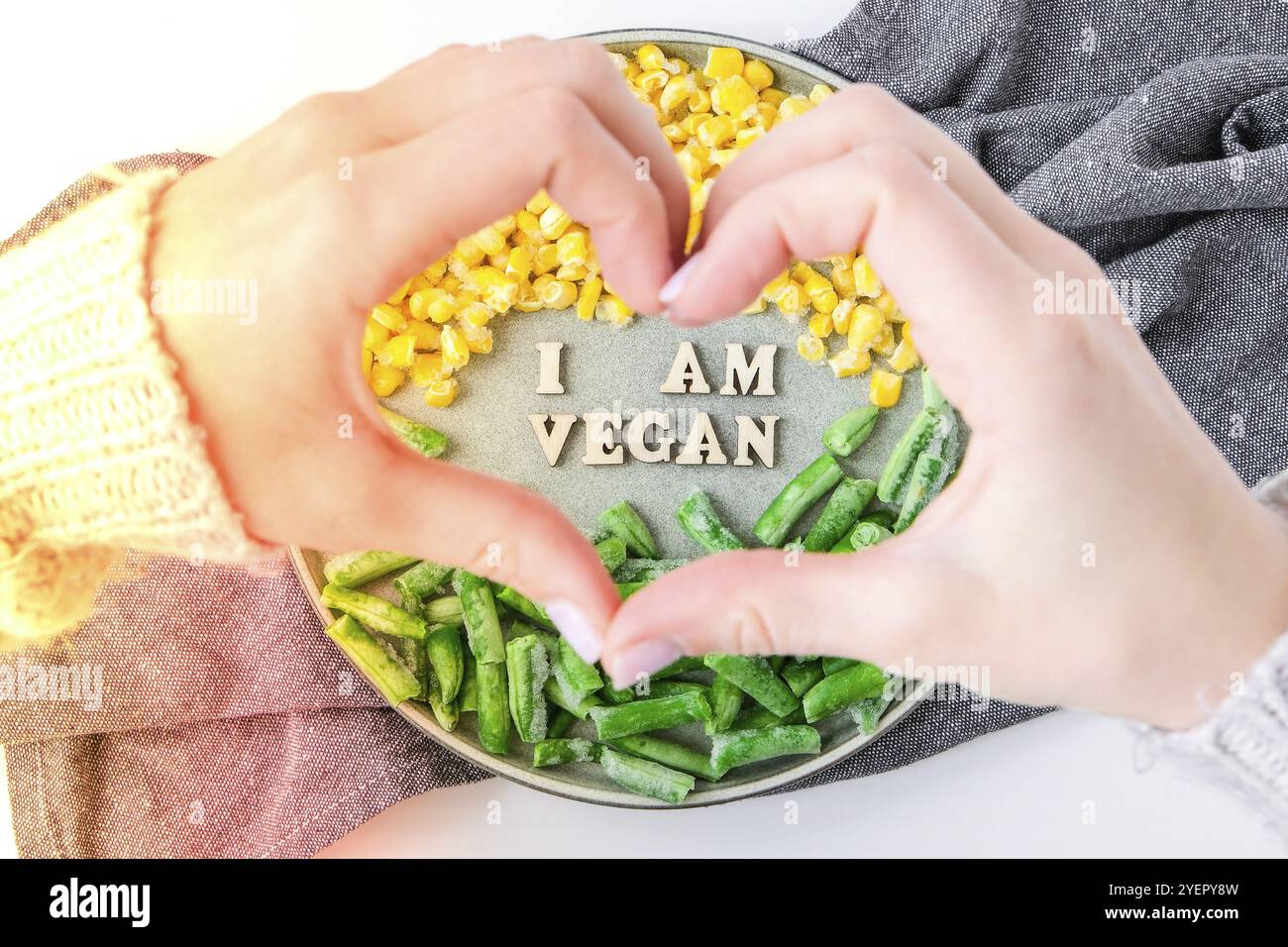 Female hands in shape of heart love I AM VEGAN text in plate. Veganism ...