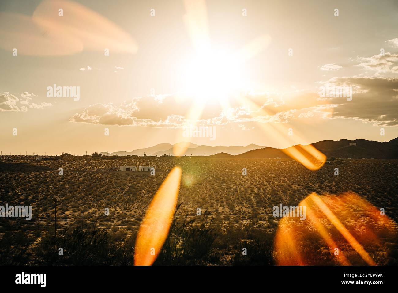 Sun setting over a vast desert landscape with lens flare effect Stock ...