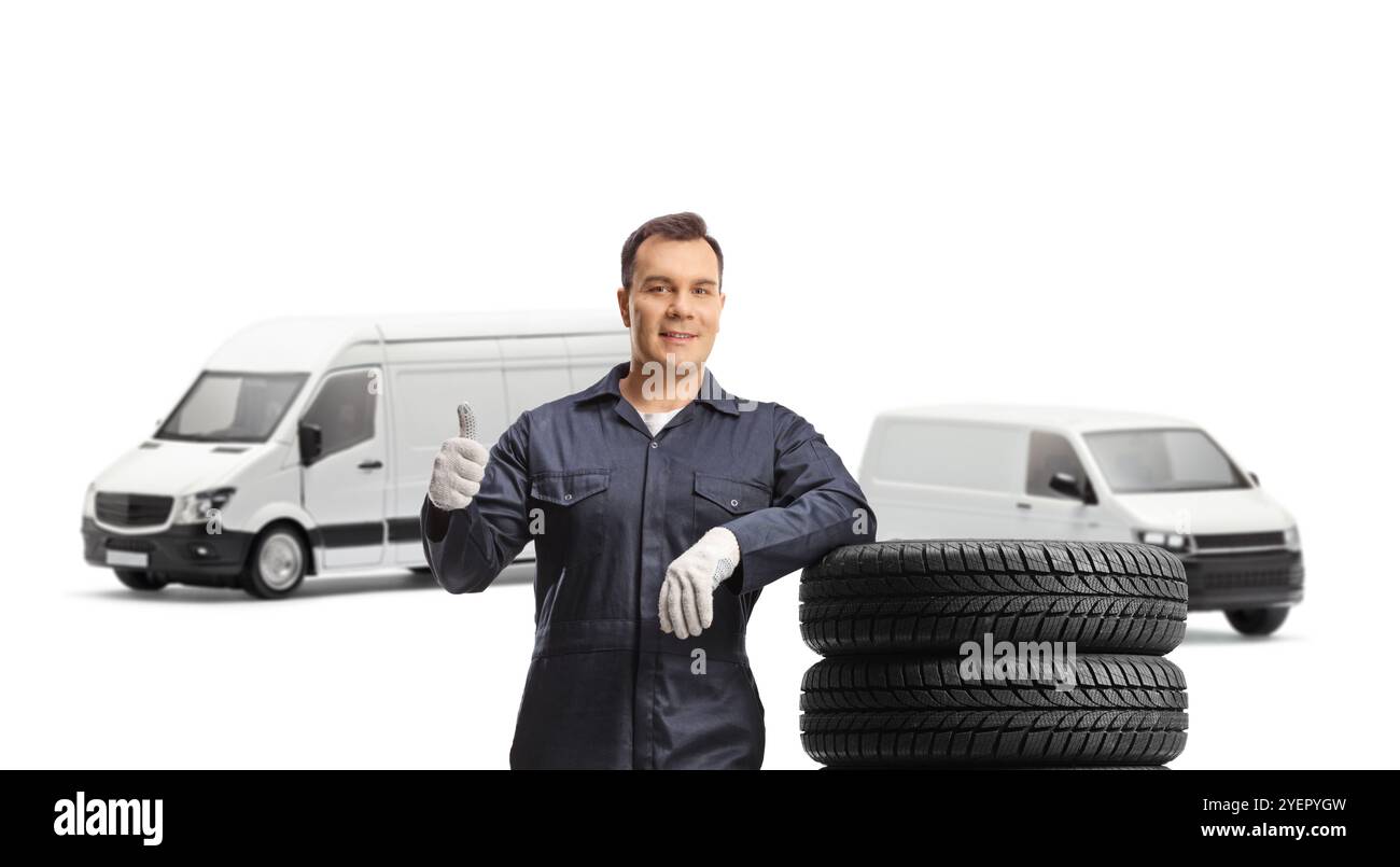 Auto mechanic worker with vans leaning on a pile of tires and showing a ...