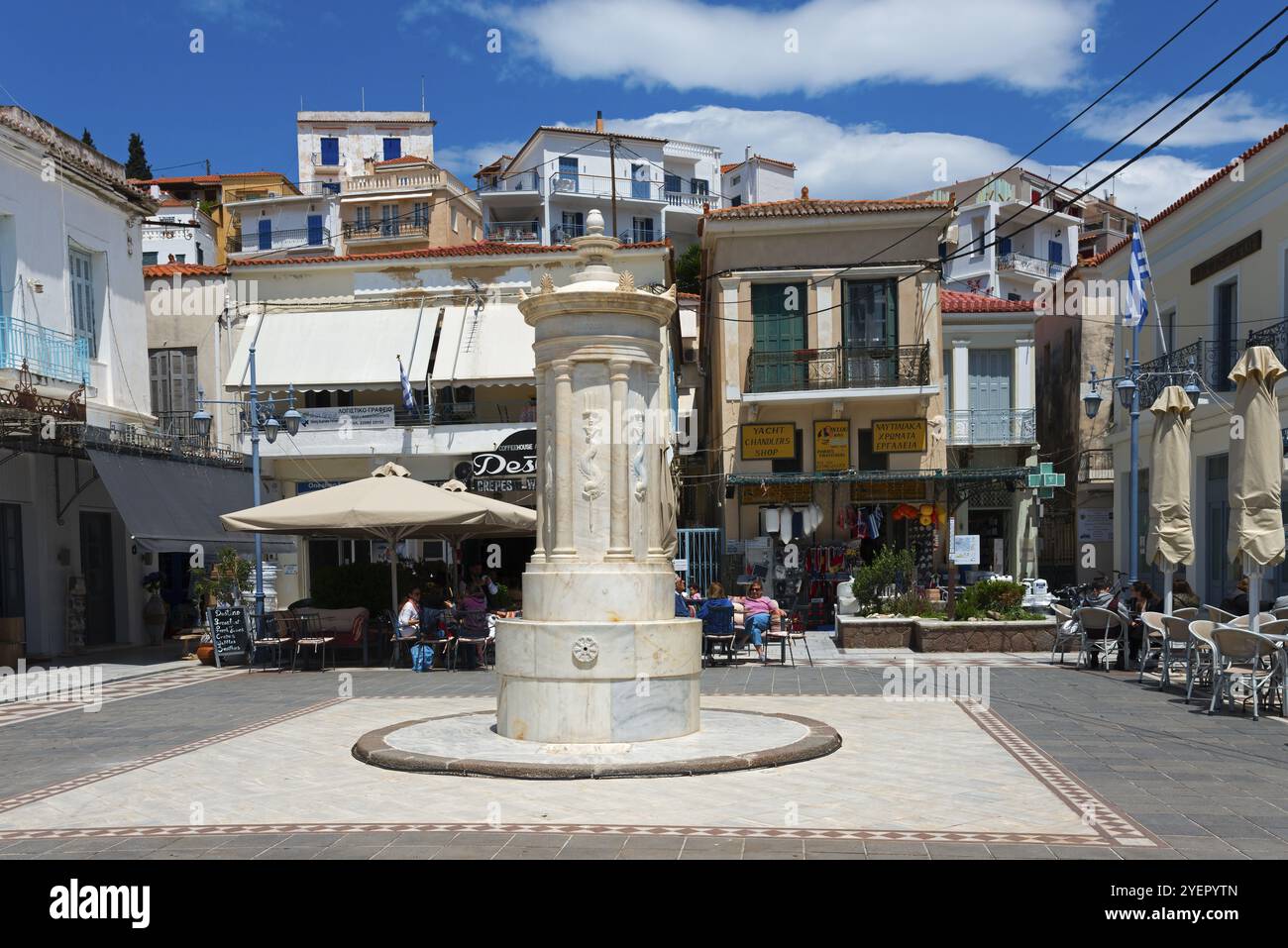 Centre of a Greek square with a stone monument, surrounded by buildings ...