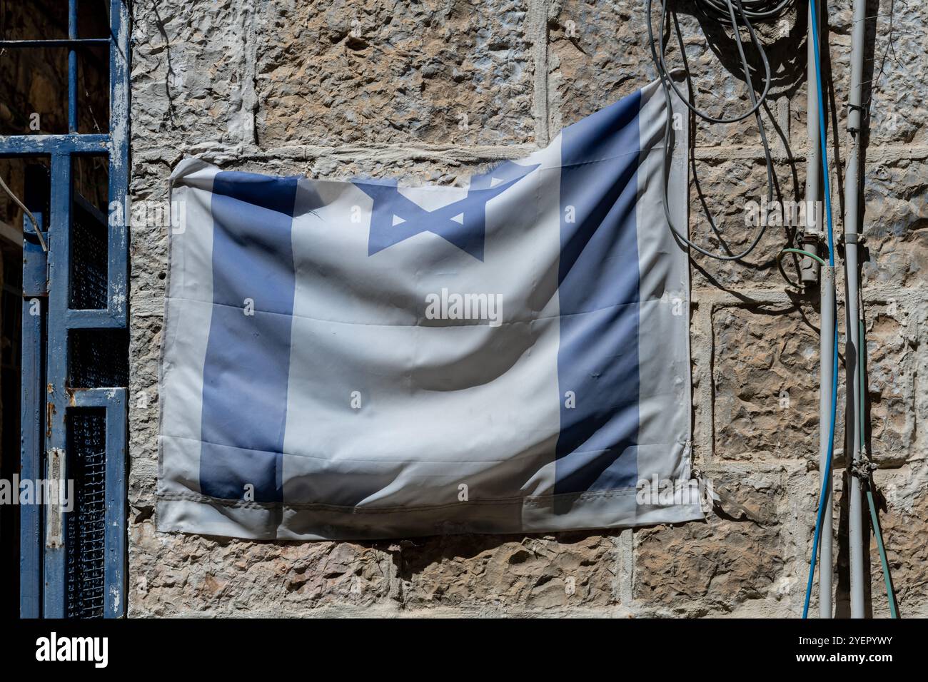 A torn and tattered, half Israeli flag with a Jewish star and blue ...