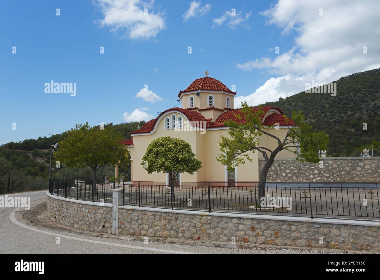 Greek church with red brick dome in a peaceful landscape under a blue ...