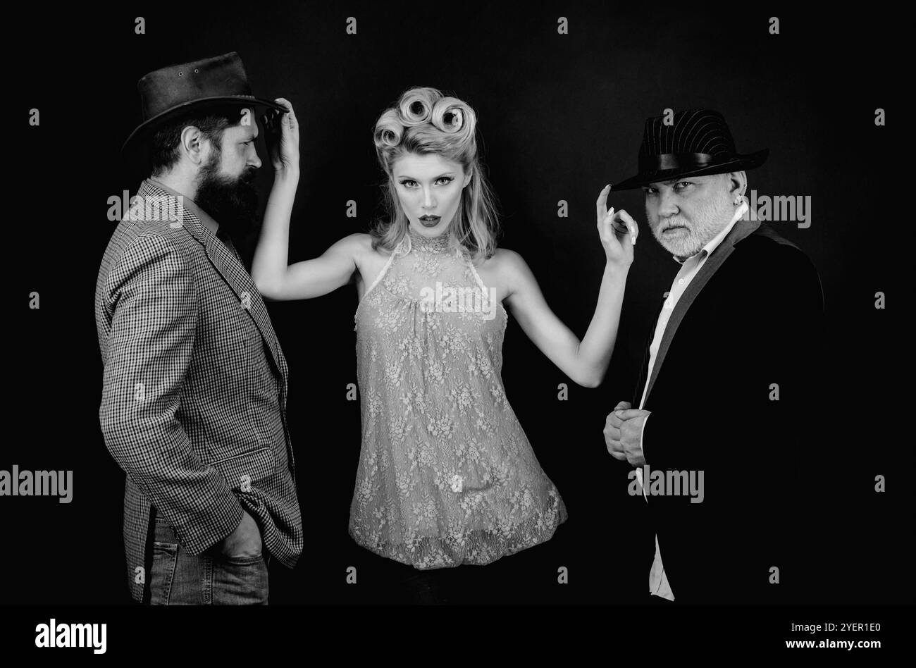 Two men in suits and a girl in an evening dress. Funny gangsters in hat ...