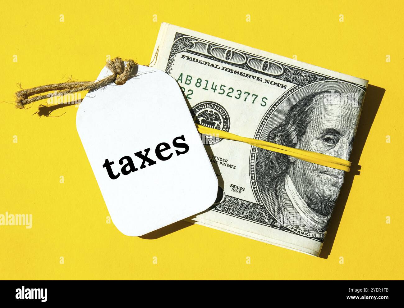 Paper note written word TAXES in black letters around Us dollars ...