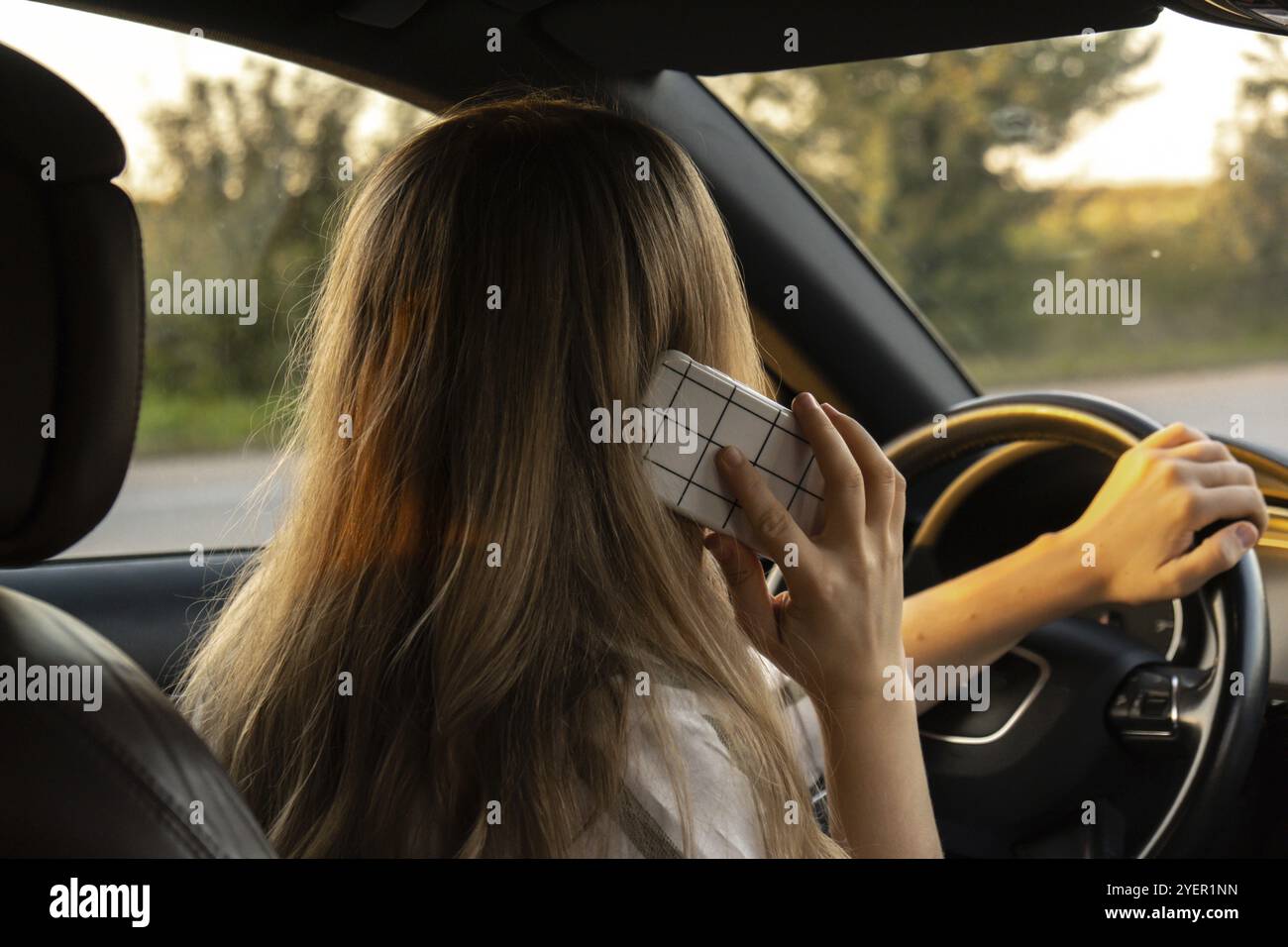 Happy young woman speaking by mobile phone while driving car. Business ...