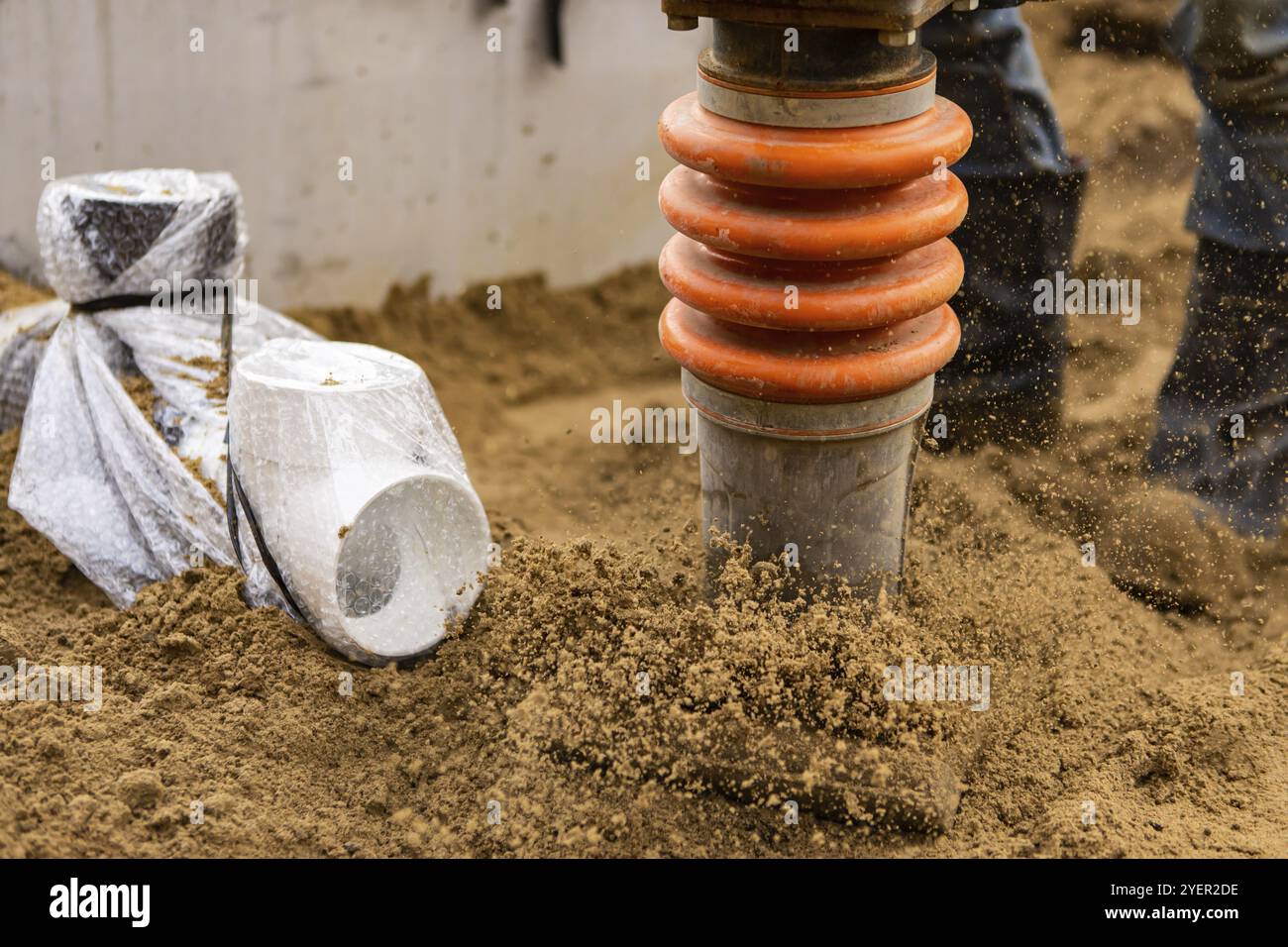Close up details of a man operating rammer, aka a tamper, at work on a ...