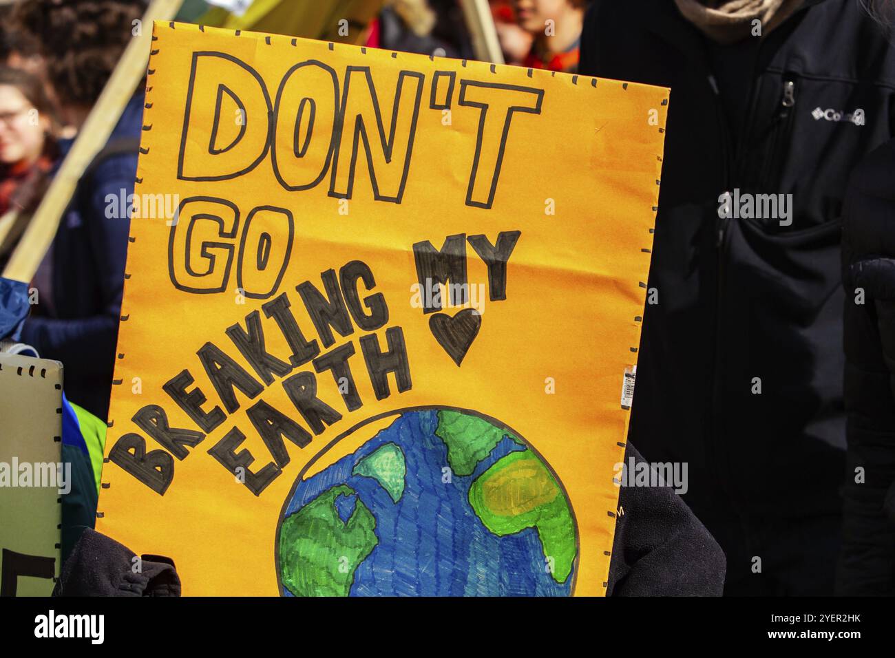 An environmental campaigner is viewed closeup holding a homemade sign ...