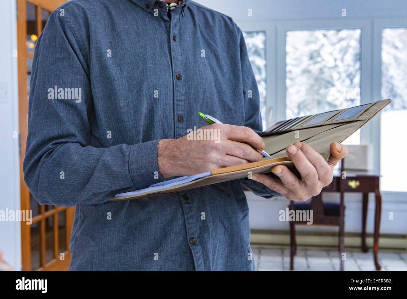 Inspector holding a notebook in his hand. Close-up of man's hands ...