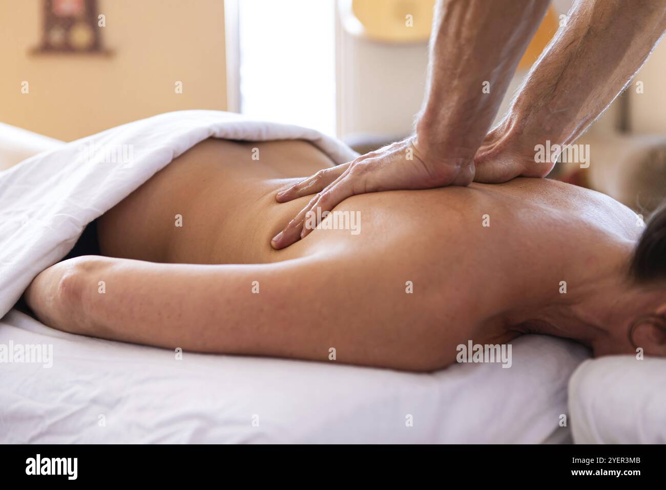 A young woman getting relaxing back massage in the spa salon. Medium ...