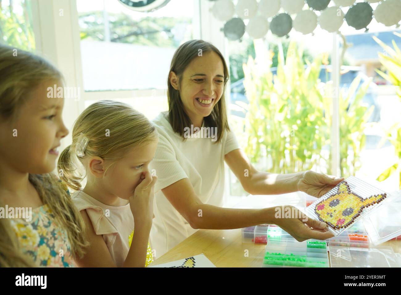 Teacher in workshop teched two girls how to assemble a thermo mosaic ...