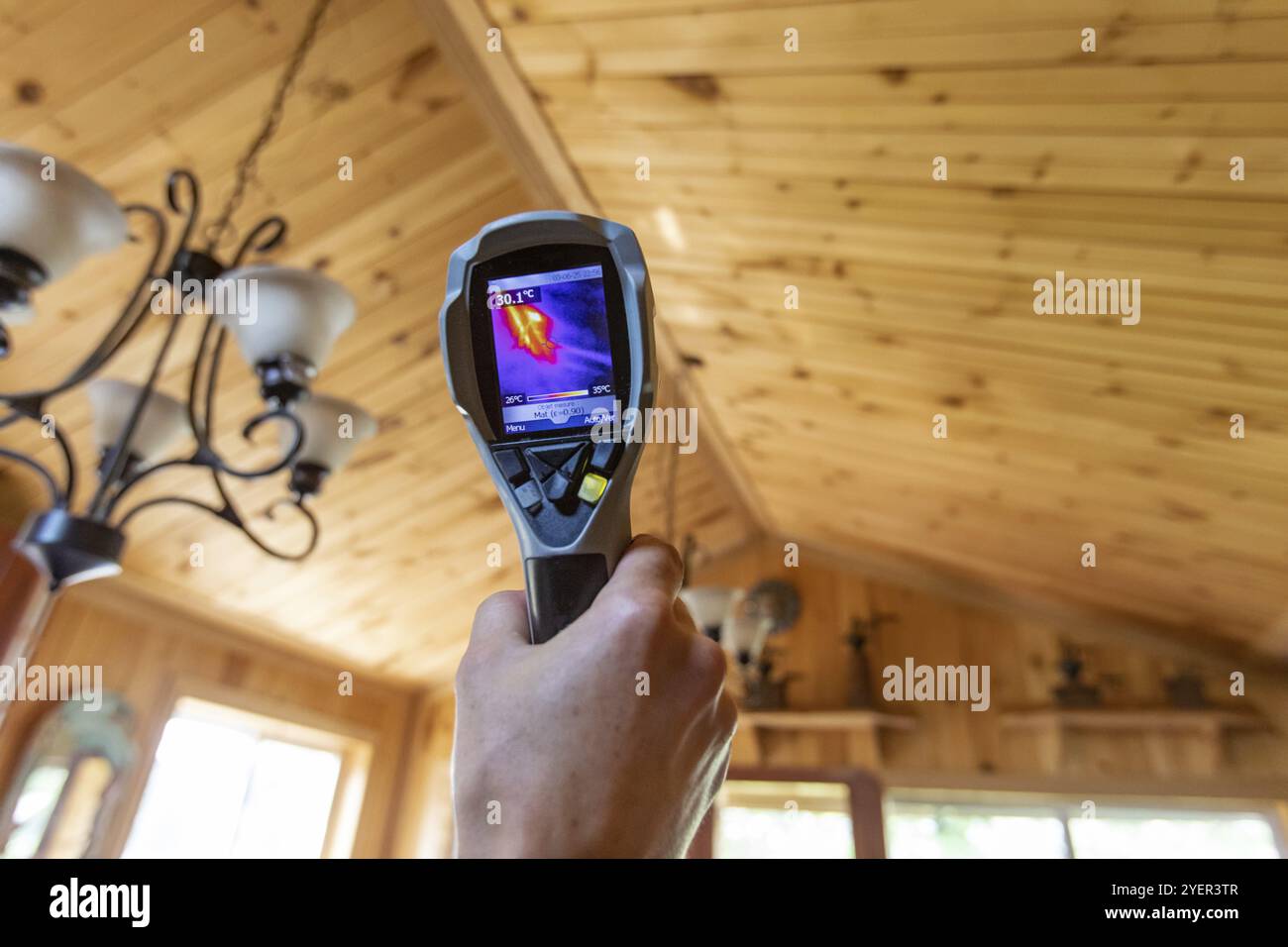 A handheld thermal imaging device is seen up-close, at work inside a ...