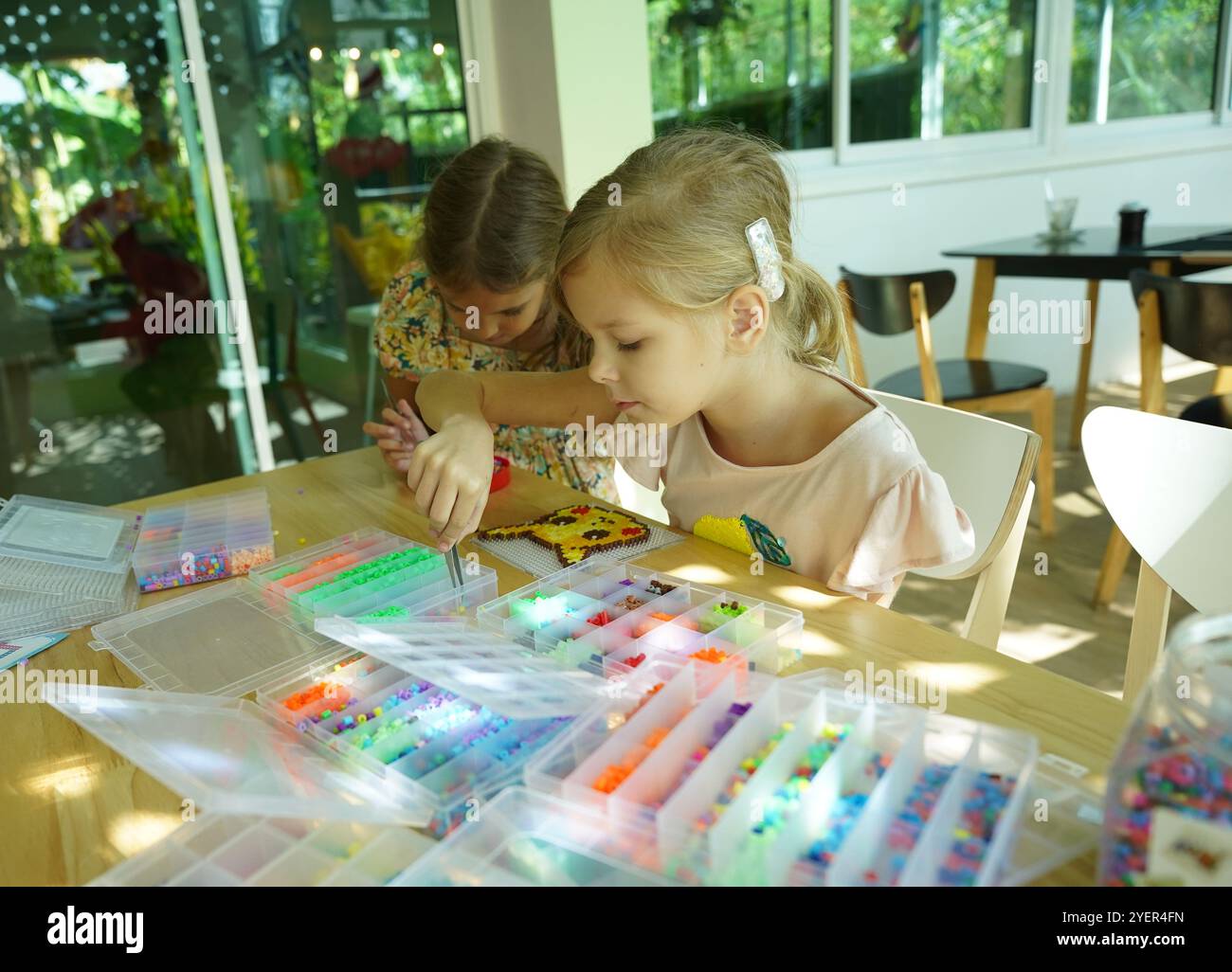 Teacher in workshop teched two girls how to assemble a thermo mosaic ...