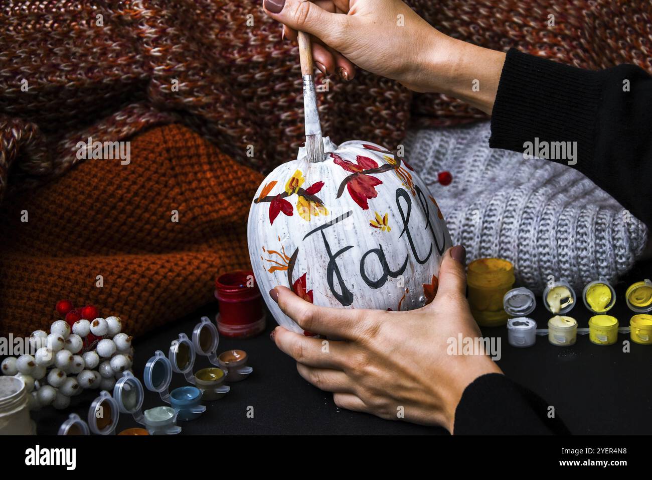 DIY. Do it yourself. Woman paints thanksgiving decorations on orange ...