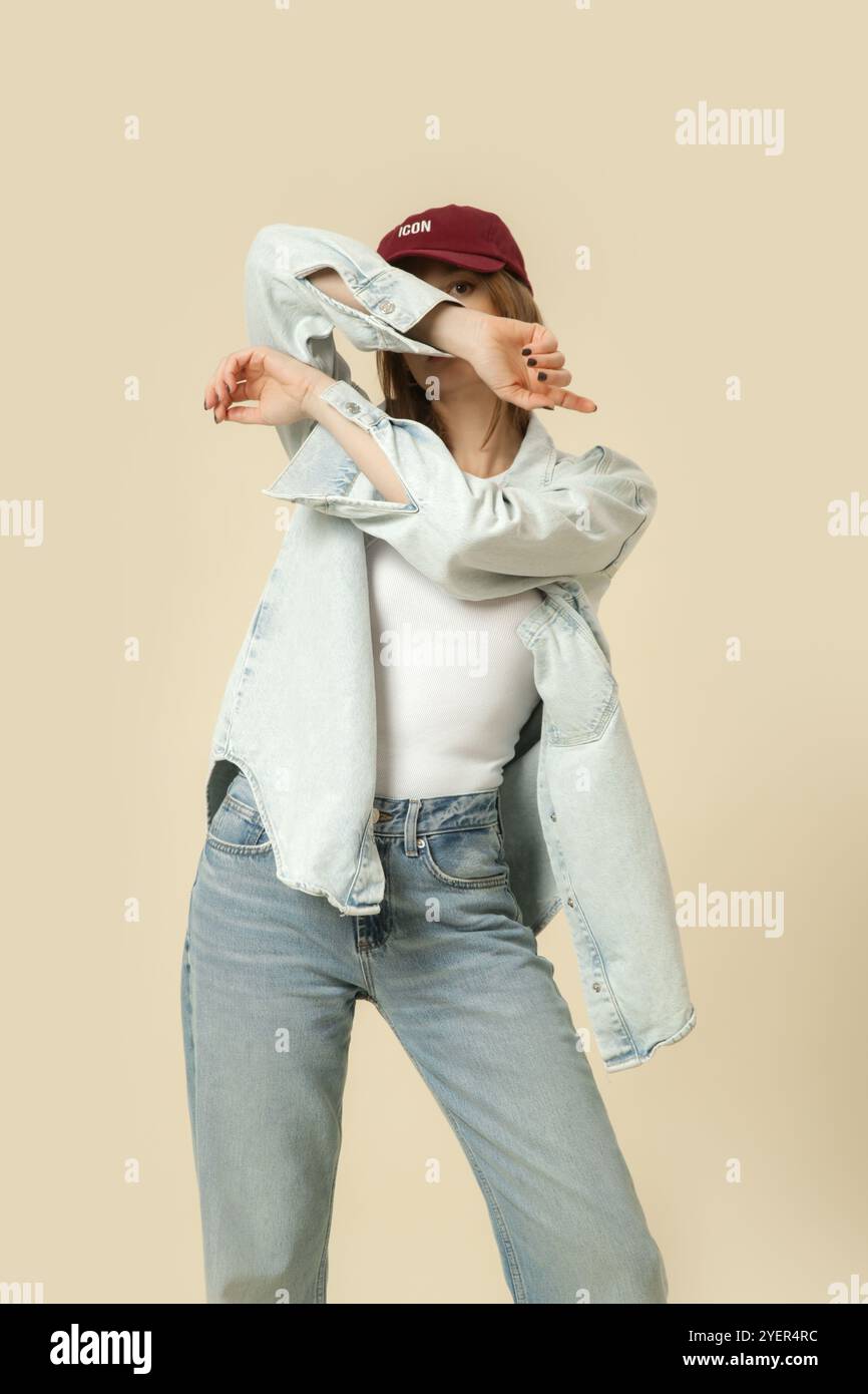 Serie of studio photos of woman in modern casual outfit, blue jeans, white tank top and denim ...