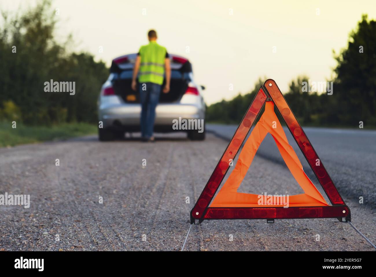Broken silver luxury car emergency accident. Man driver installing red ...