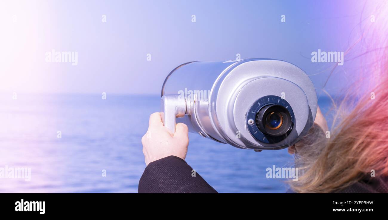 Tourist looking through coin operated binoculars. Binocular telescope ...