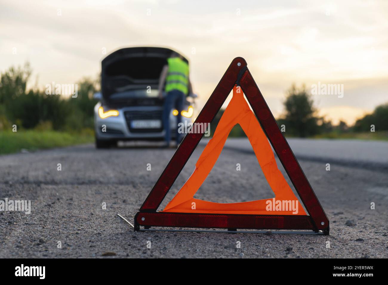 Broken silver luxury car emergency accident. Man driver installing red ...