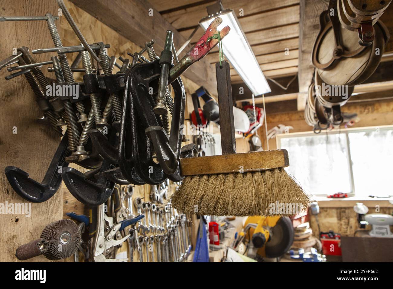 A closeup view of G-clamps hung inside a metalwork garage. Handy tools ...