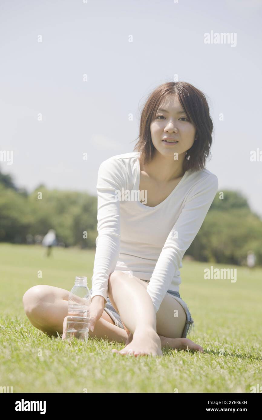 Female sitting on lawn Stock Photo - Alamy