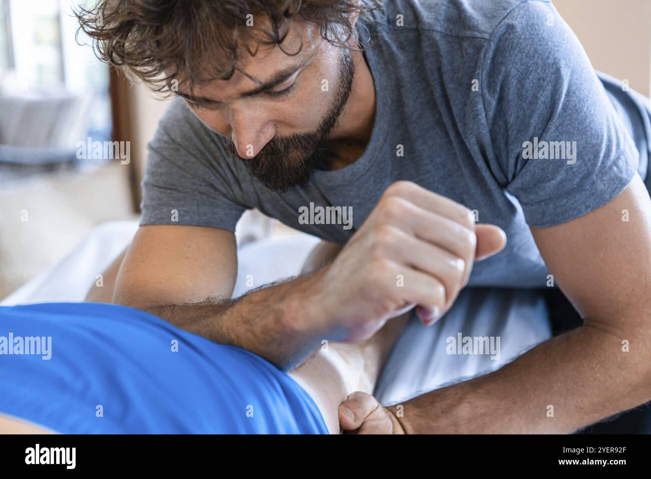 Close-up view of massage therapist giving body massage to sportsman ...