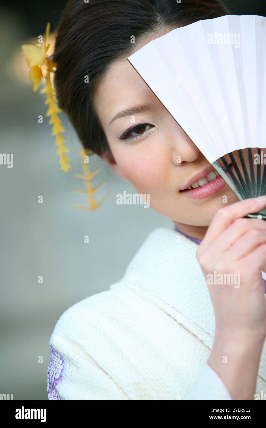 Woman hiding her face with a fan Stock Photo - Alamy