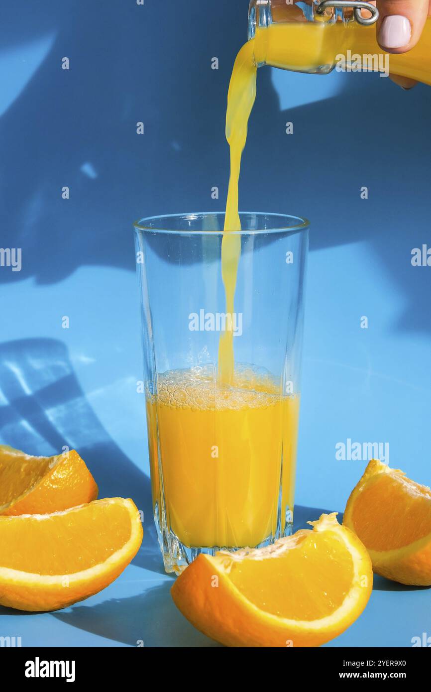 Pouring orange juice stream from jug into glass of squeezing Orange ...