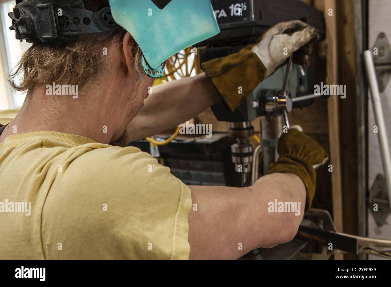View over the shoulder of a metalworker wearing personal protective ...