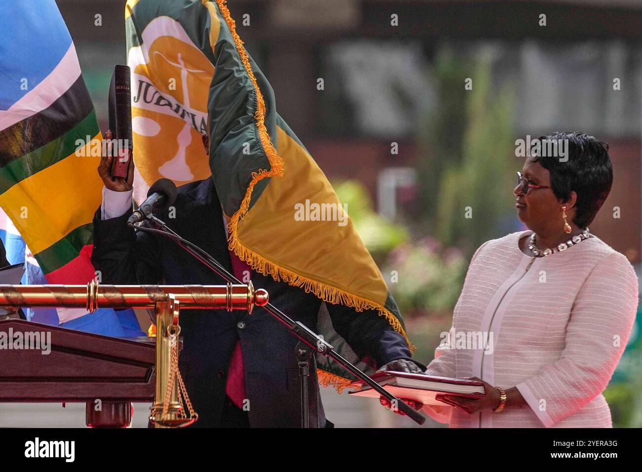 Kenya's new Deputy President Kithure Kindiki, left, is covered by a ...