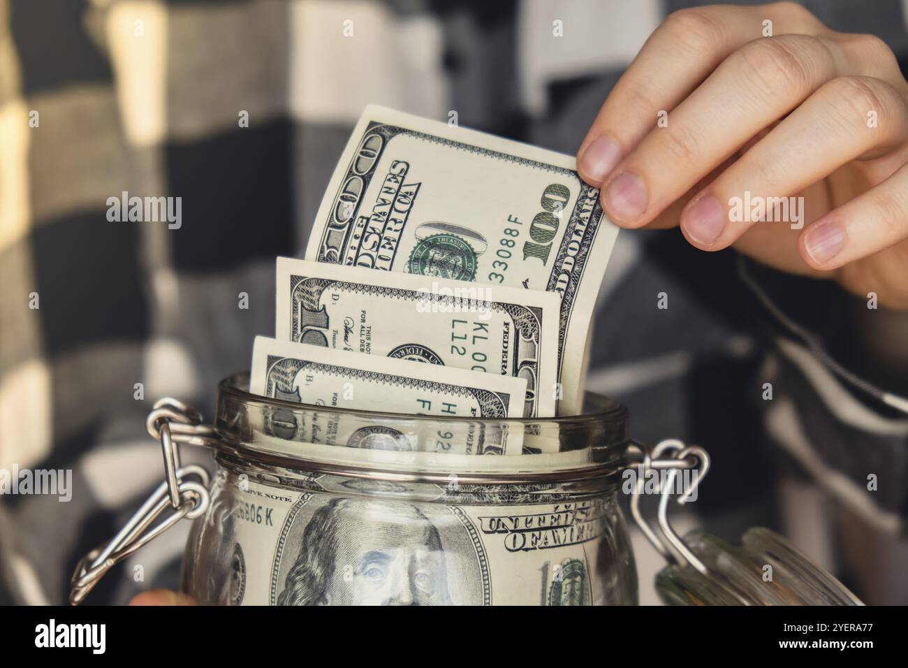 Dollar banknote saving money in glass jar. Unrecognizable woman ...