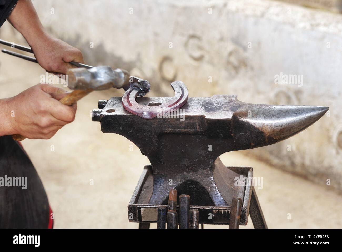 Blacksmith working on the anvil, making a horseshoe Stock Photo - Alamy