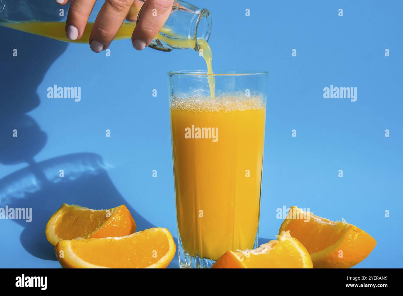 Pouring orange juice stream from jug into glass of squeezing Orange ...