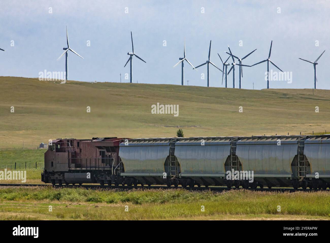Row of metallic wagons of a Canadian freight train running between ...