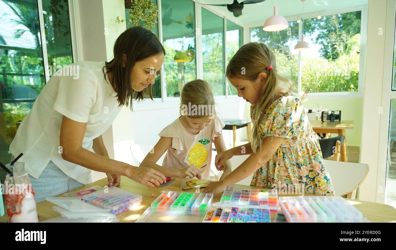 Teacher in workshop teched two girls how to assemble a thermo mosaic ...