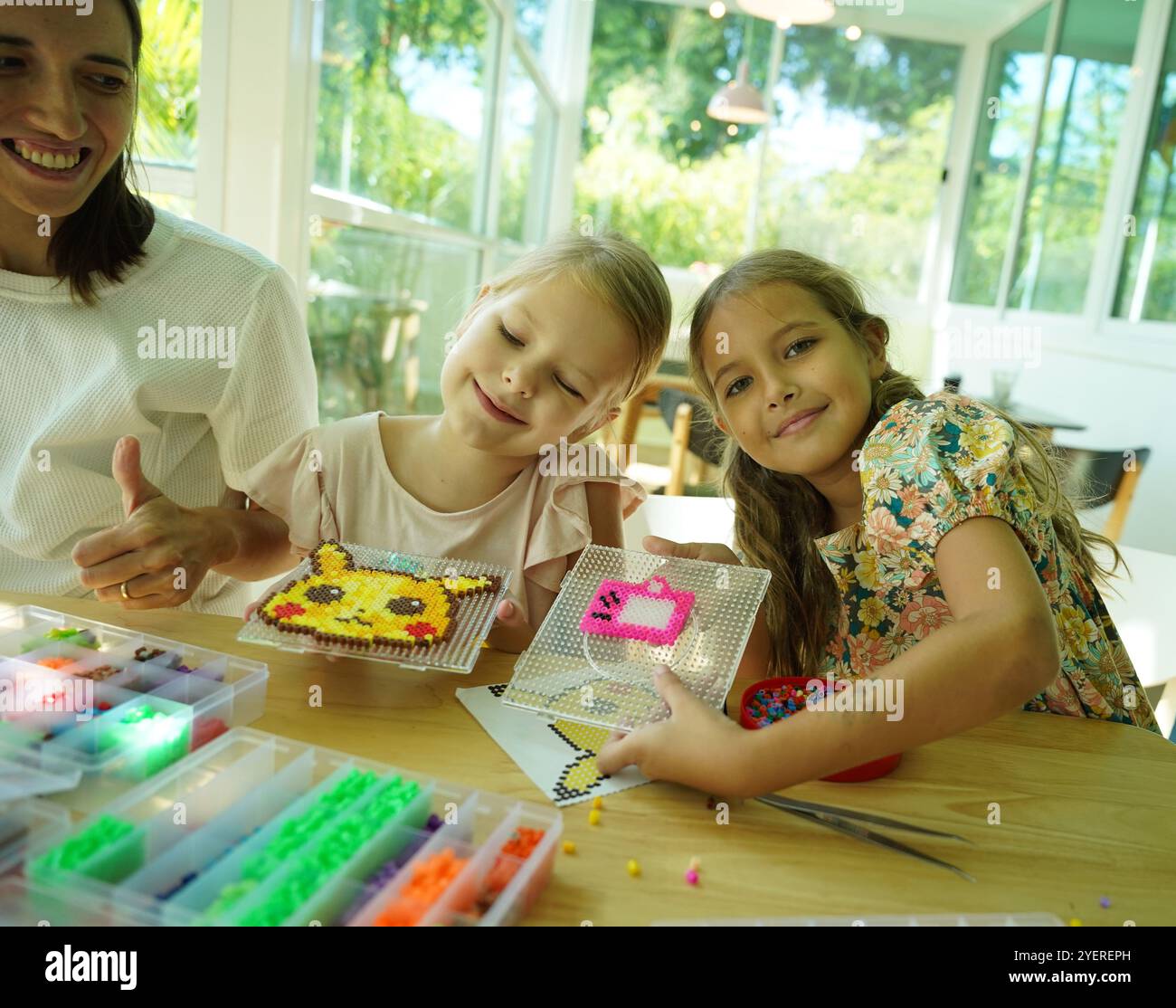Teacher in workshop teched two girls how to assemble a thermo mosaic ...
