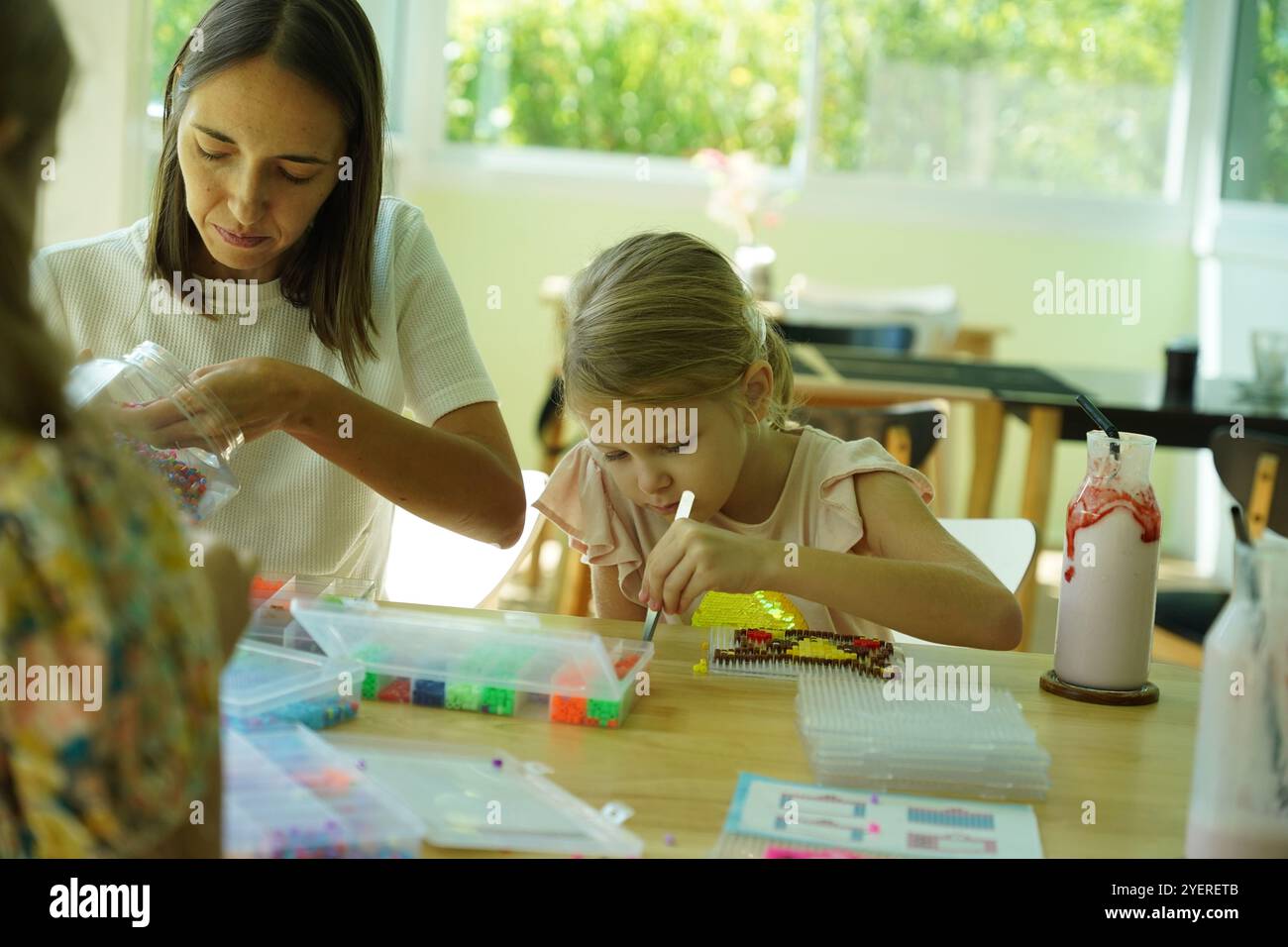 Teacher in workshop teched two girls how to assemble a thermo mosaic ...