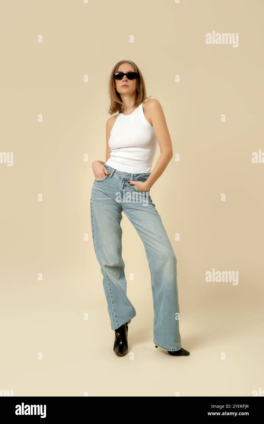 Serie of studio photos of woman in classic basic outfit - blue jeans and white tank top Stock ...